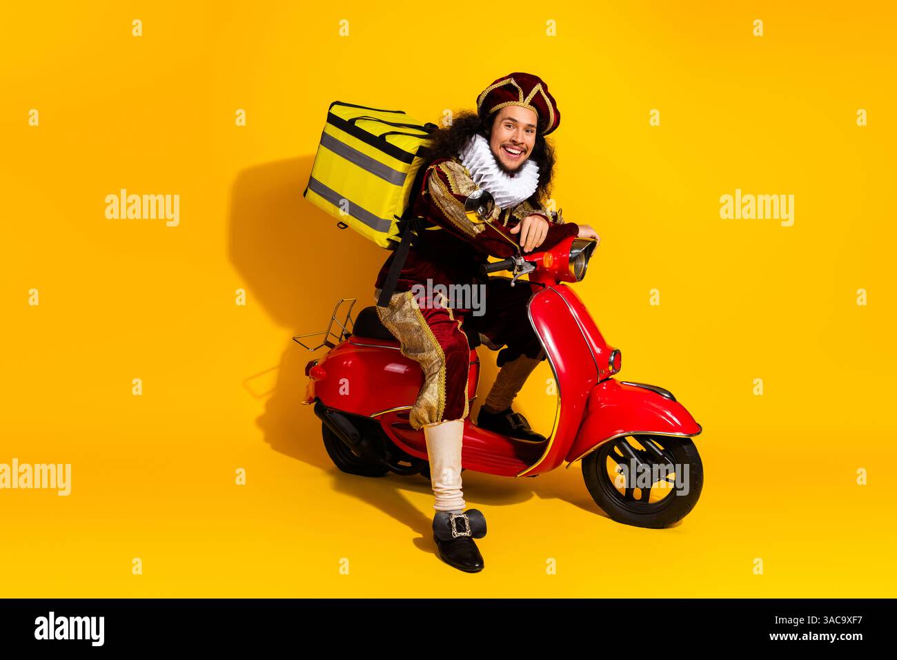 Smiling nobleman in masquerade costume posing on modern scooter with ...
