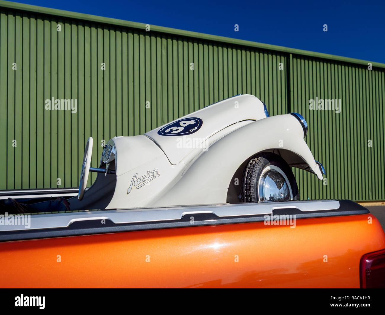 A Austin J40 childs pedal car in the back of a colourful pickup truck ...