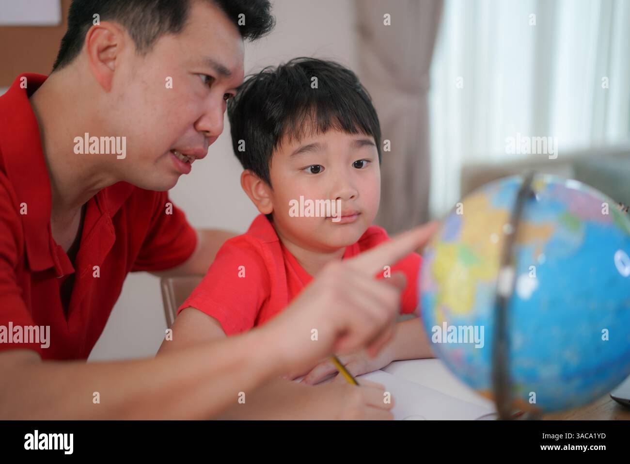 father and son explore the globe at home, nurturing curiosity, bonding, and interactive learning ...