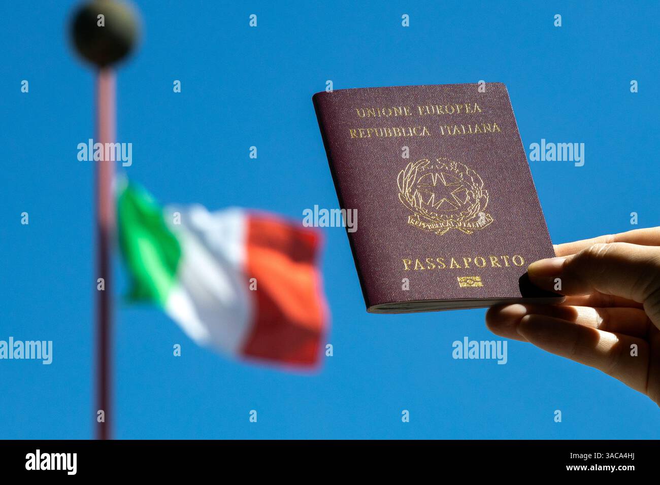 Italian citizenship - Hand holding a passport with Italian flag in the ...