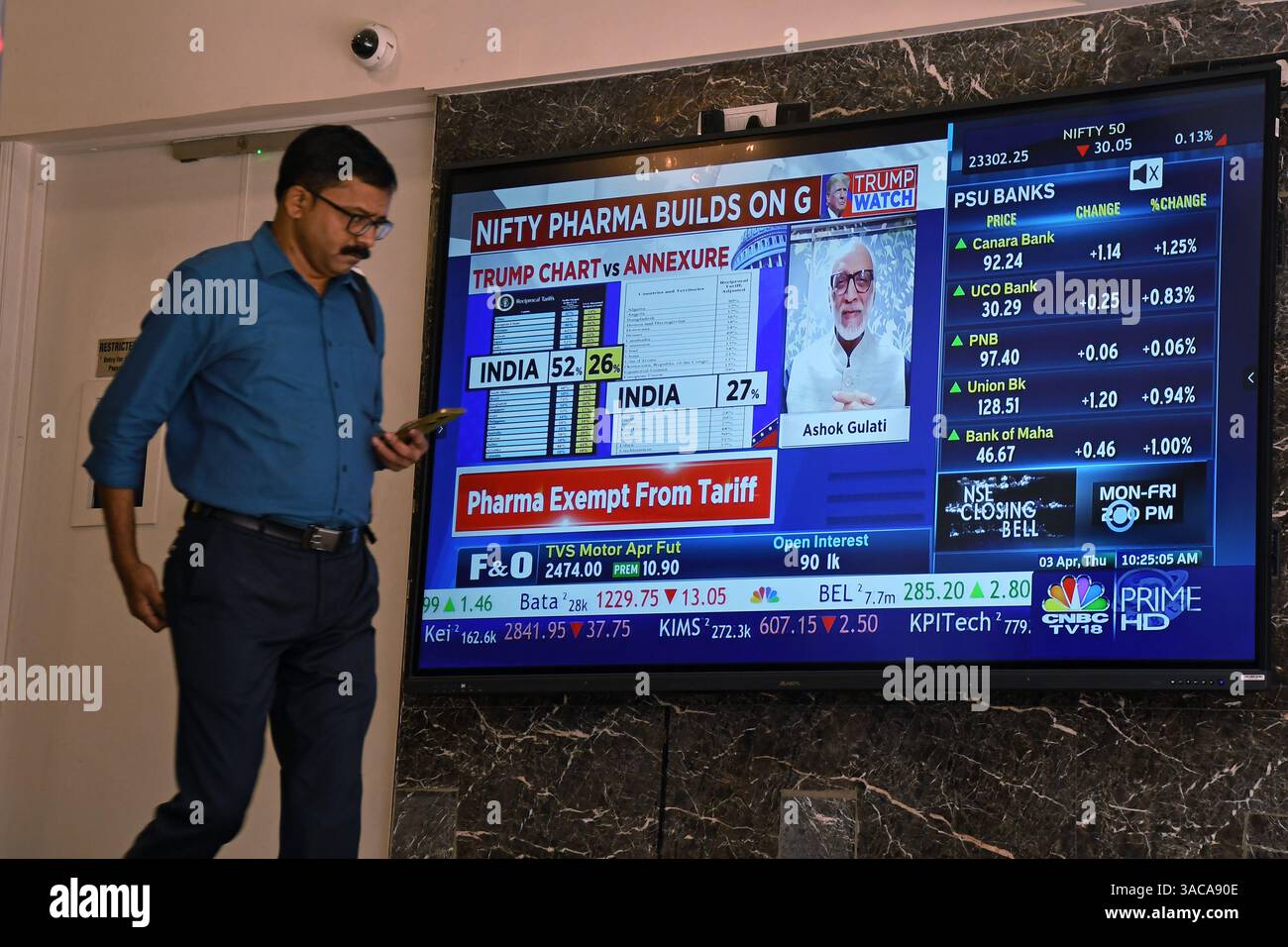 Mumbai, India. 03rd Apr, 2025. A man walks past a LED screen displaying ...