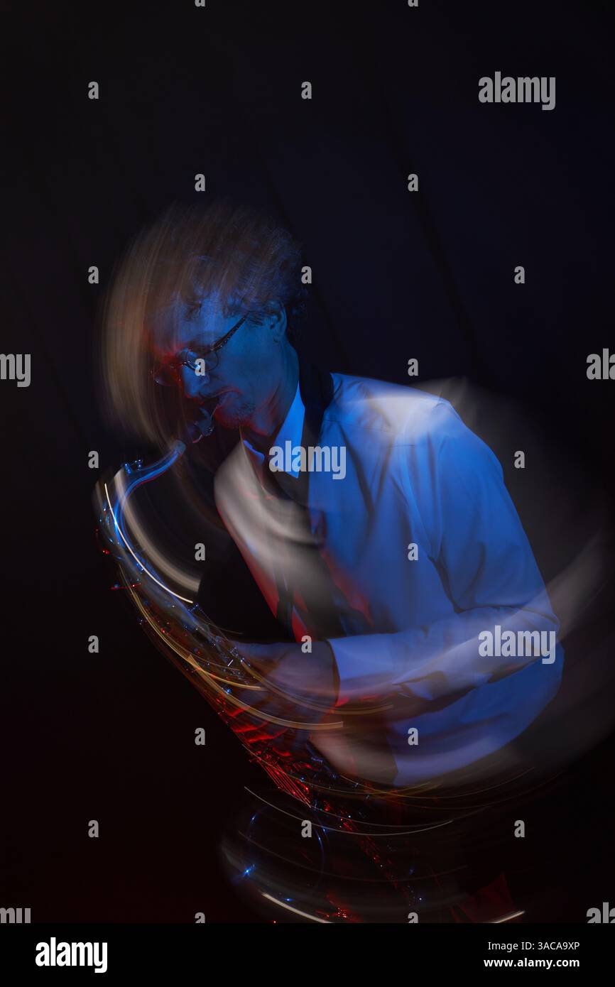 Vertical dynamic shot of driven male saxophonist playing intricate ...