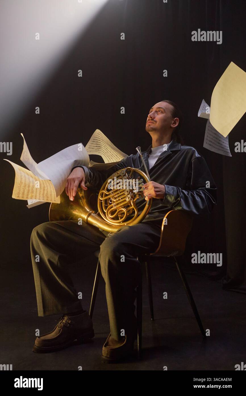 Vertical dynamic shot of professional male jazz player sitting in chair ...