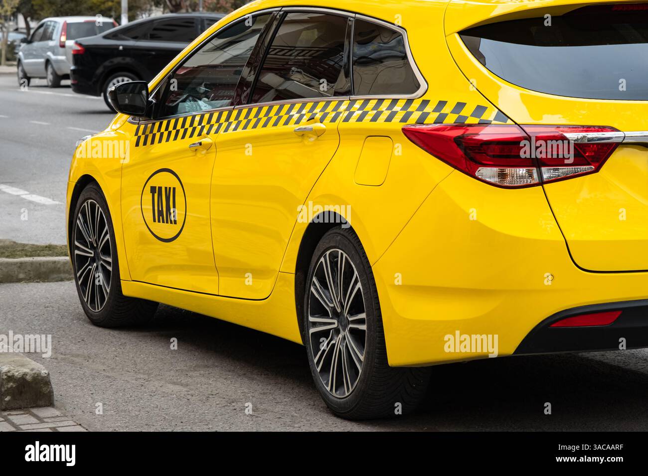 A bright yellow taxi cab parked on urban city street. Close up of ...