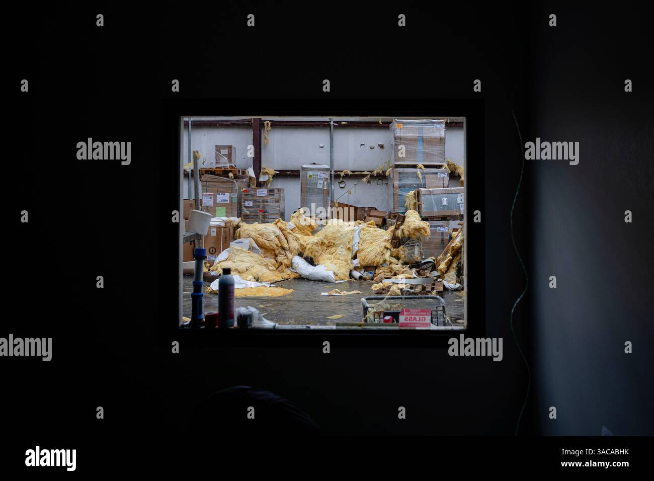 An interior office window looks into the damaged warehouse of Specialty ...