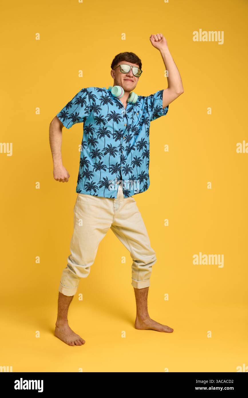 Full body photo of expressive young man dancing barefoot with ...