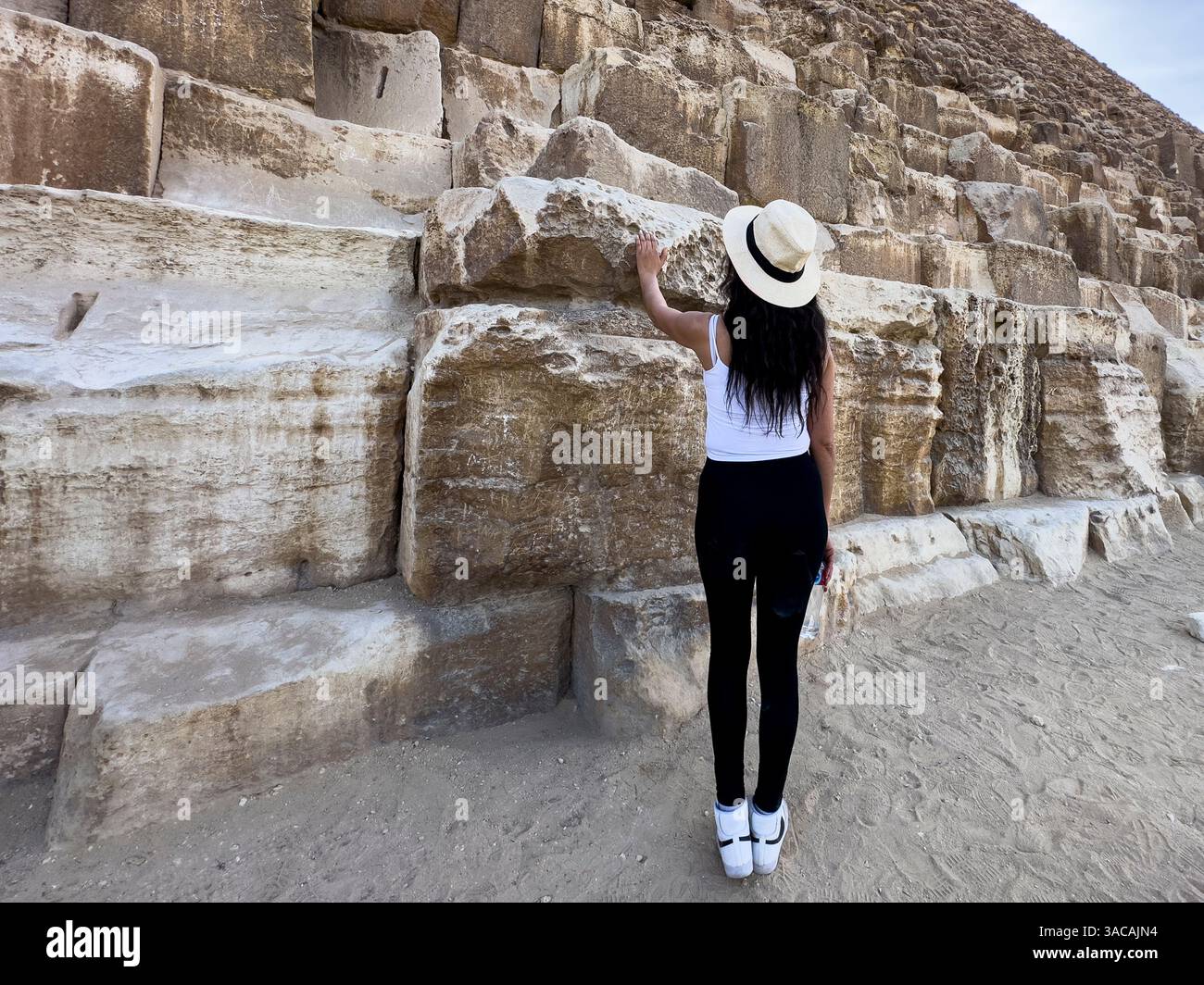 See a tourist make contact with Keops Pyramid, a world wonder in Giza ...