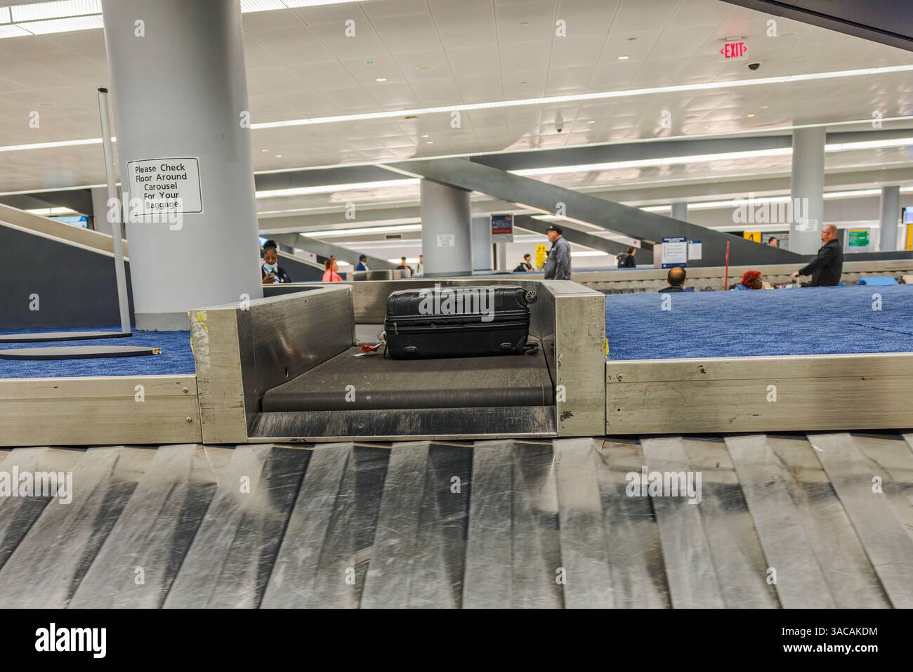 Black suitcase arriving on baggage carousel inside modern airport ...