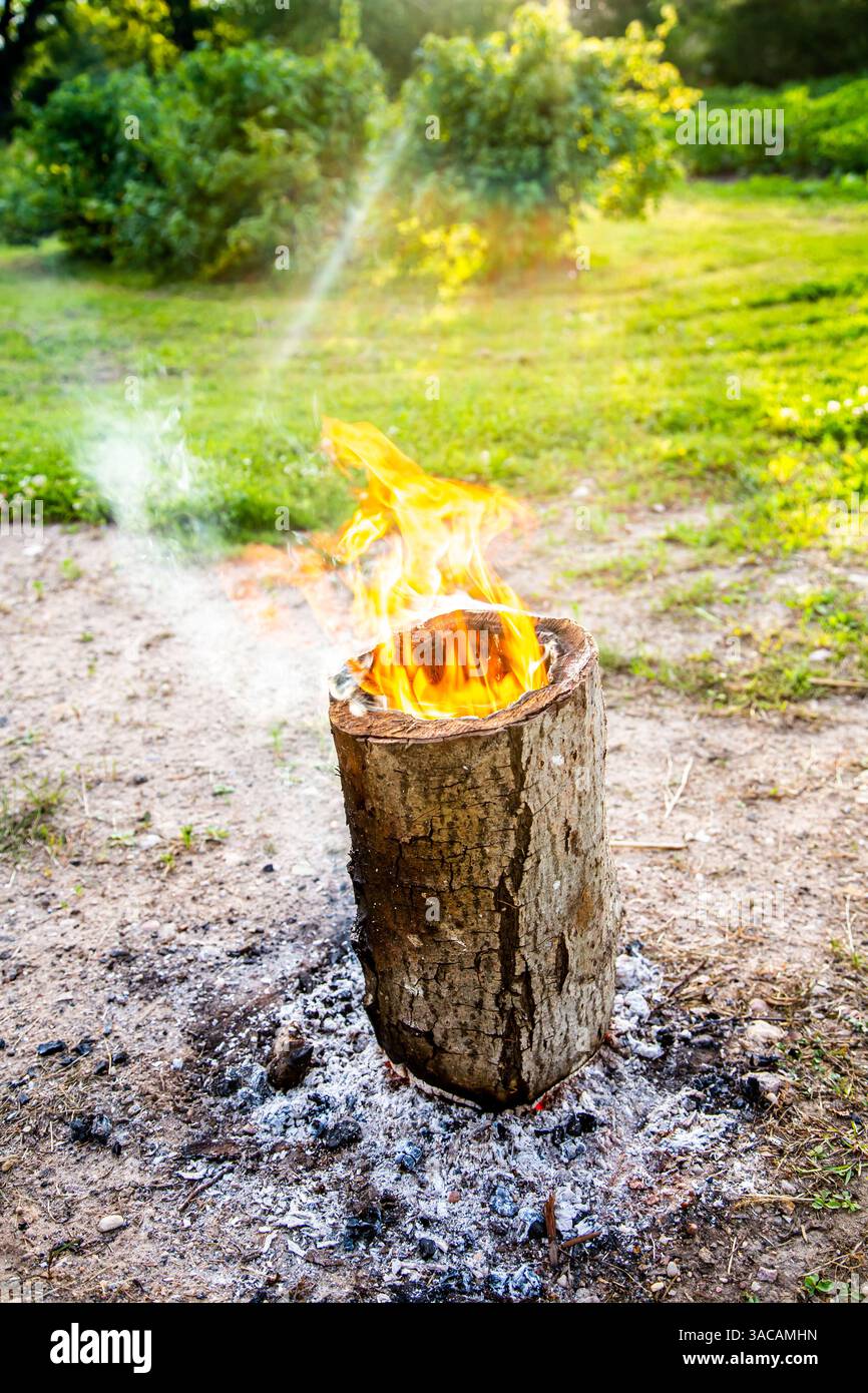 Round wood log with chopped out middle and side hole for burning fire ...