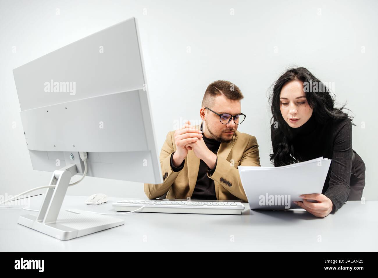 Two versatile business analysts discussing data management using a laptop. Concept consulting ...