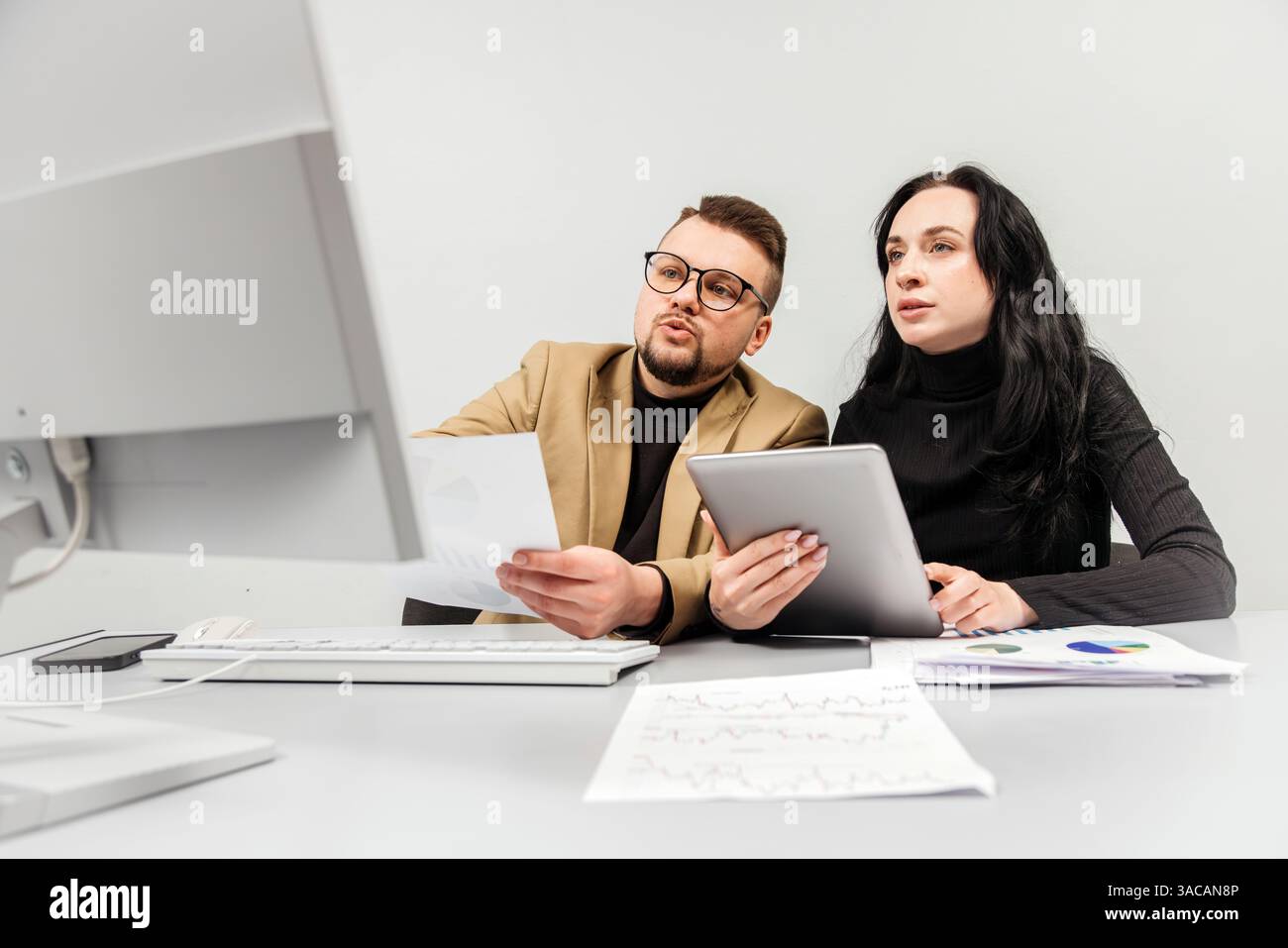 Two members of a finance team working together on a project during a ...