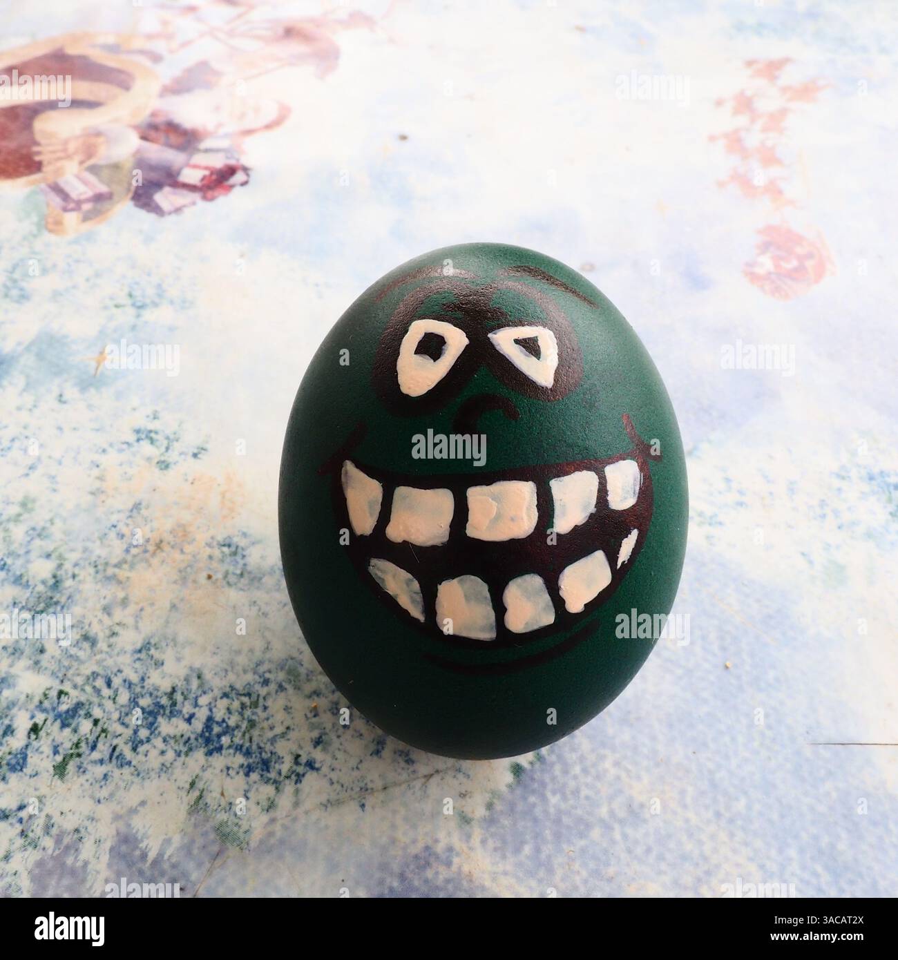 Easter egg dyed green with a painted laughing face. Cool grimace with ...