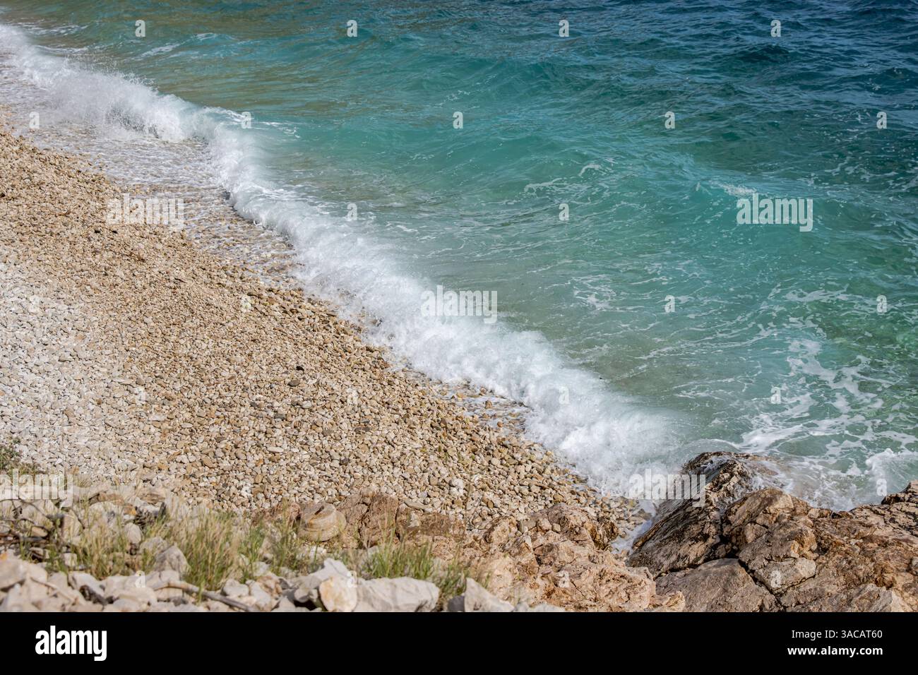 Beautiful pebbles beach with waves and blue sky. Relaxing aerial scene ...