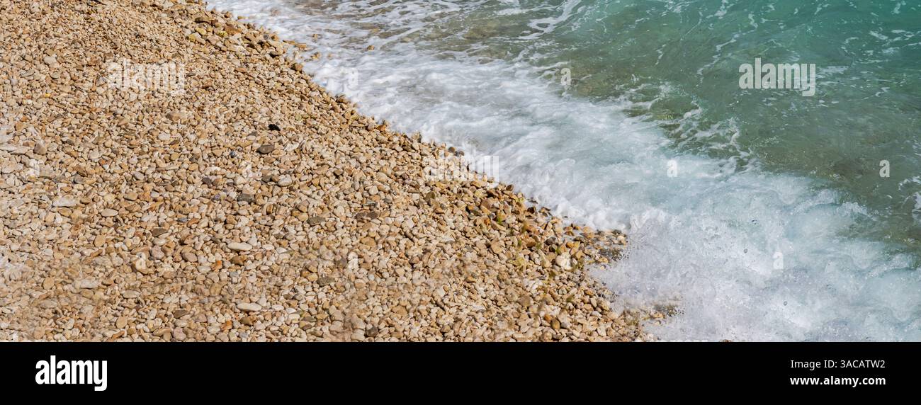 Beautiful pebbles beach with waves and blue sky. Relaxing aerial scene ...