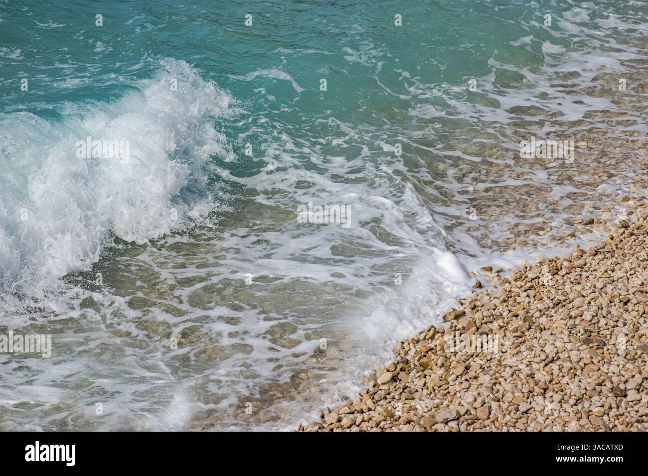 Beautiful pebbles beach with waves and blue sky. Relaxing aerial scene ...