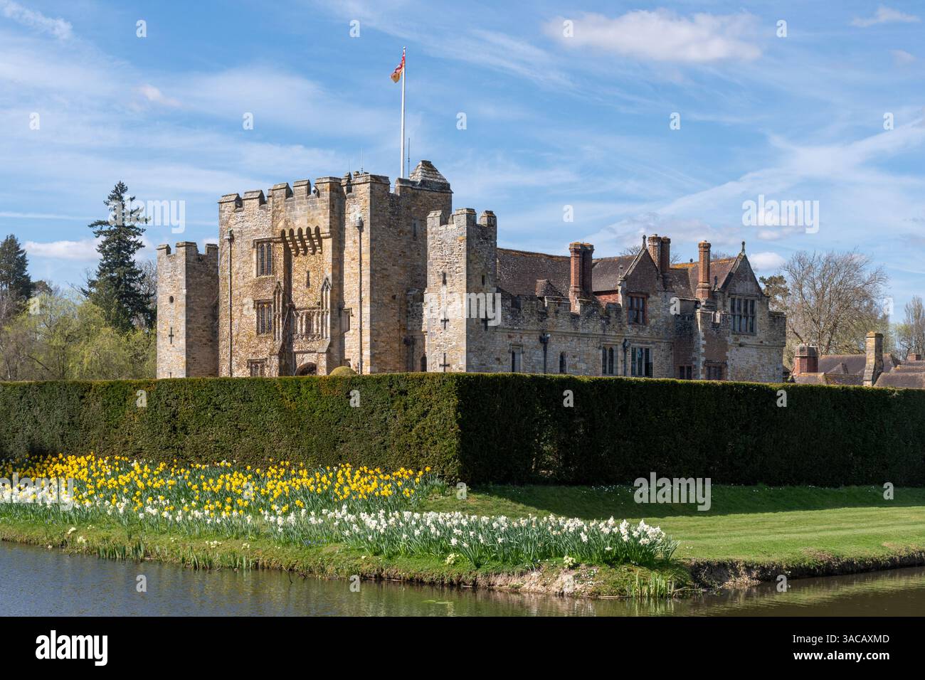 View of Hever Castle and gardens with daffodils in flower on a sunny ...