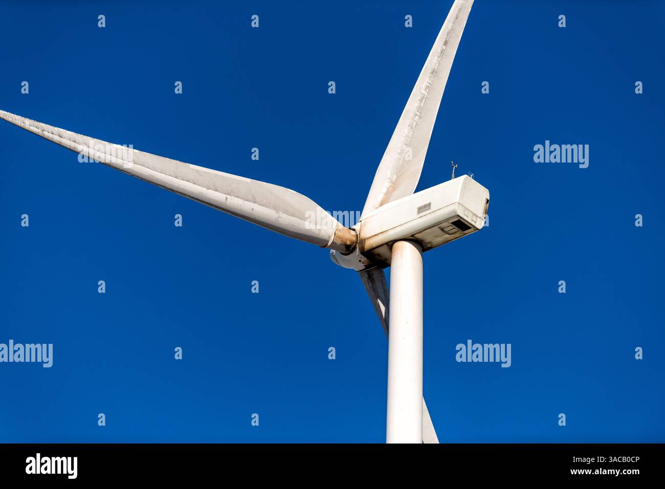 Wind turbine closeup isolated of windmill propeller against blue sky in ...