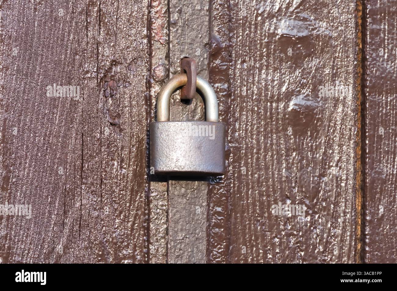 Locked security padlock on vintage garage or storage door. No entry or ...