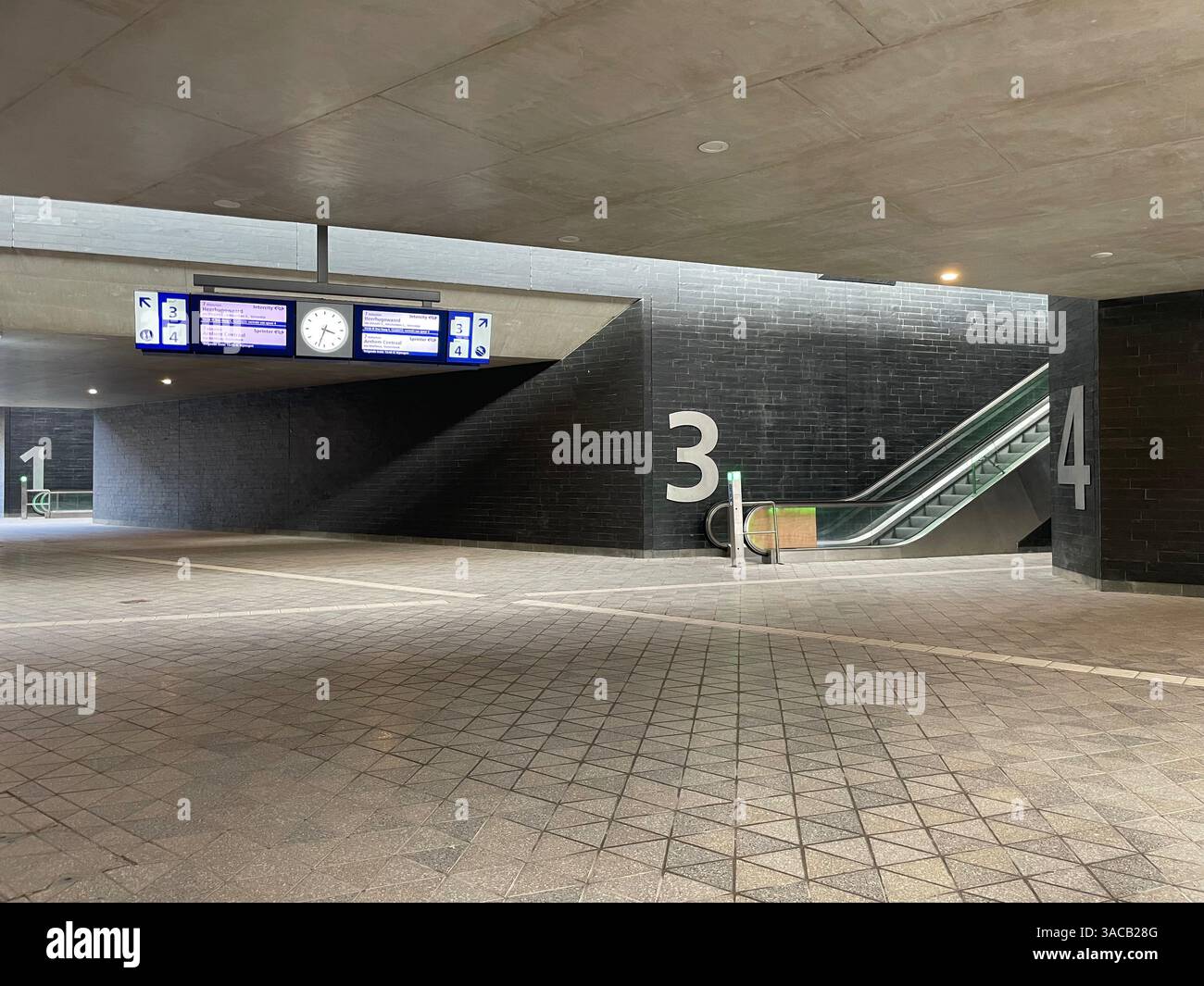 A modern train station interior showcases departure boards, a clock ...