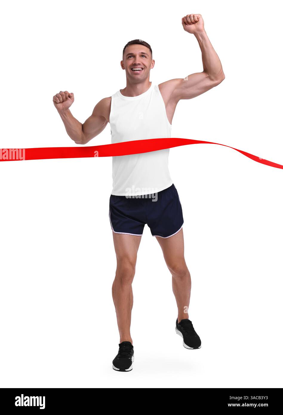 Happy sportsman crossing red finish line ribbon on white background ...