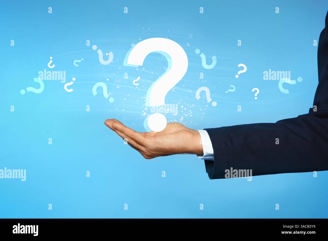 Businessman holding virtual question mark on light blue background ...