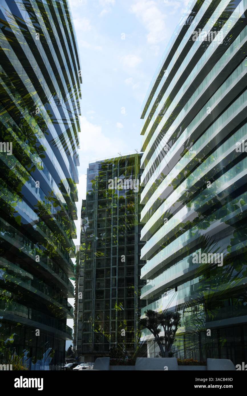Modern buildings and lush trees against blue sky, double exposure. Low ...