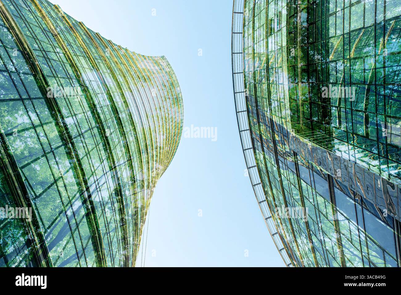 Modern buildings and lush trees against blue sky, double exposure. View ...