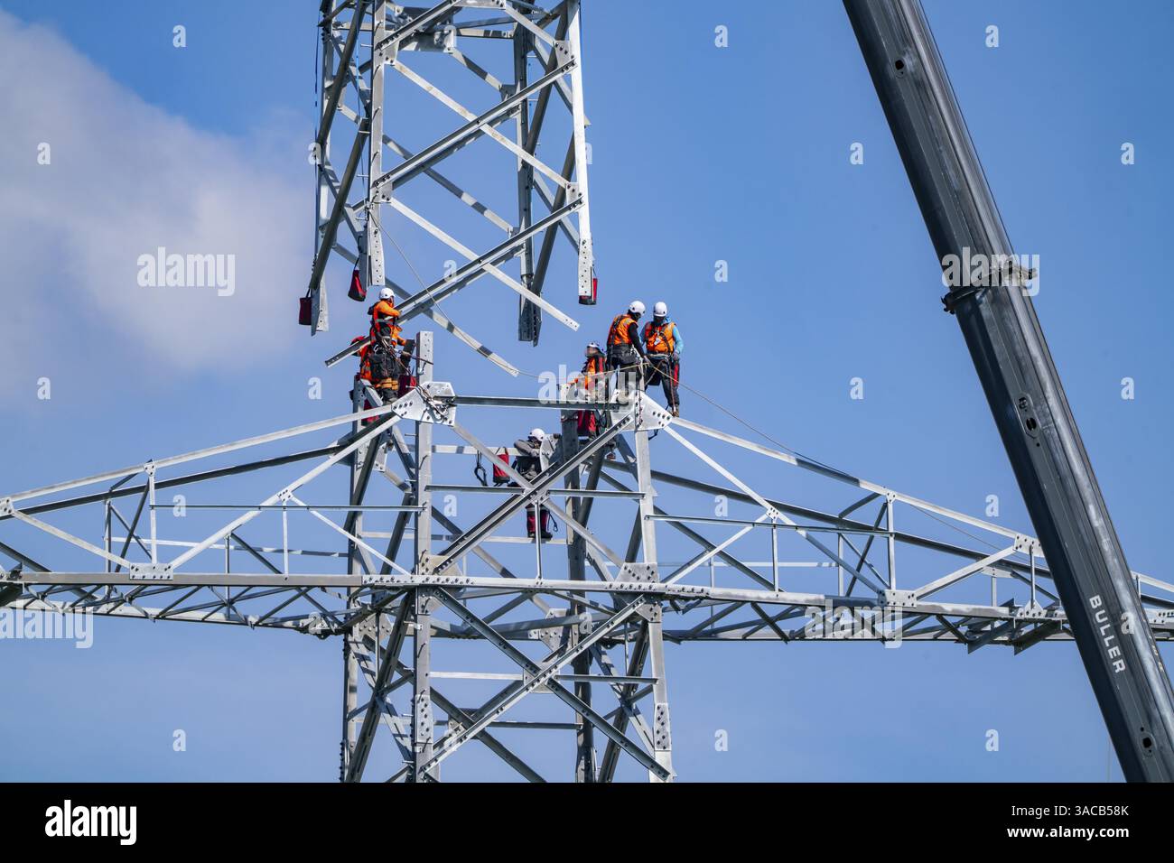 Fitters erecting a steel lattice tower as part of a 380 KV extra-high ...