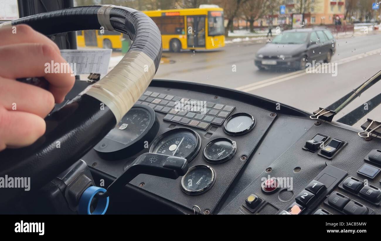 Bus driver holding steering wheel and driving on a city road Stock ...