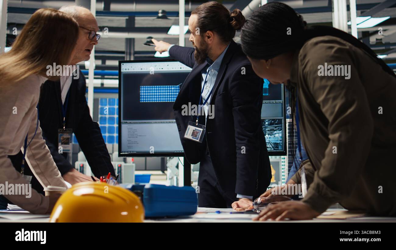 Photovoltaics factory industrial production managers looking over schematics, planning work on ...