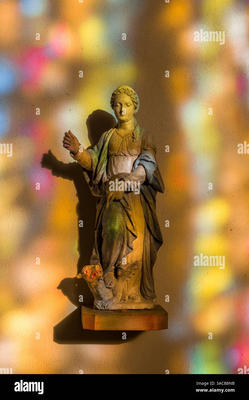 Church statue in light through stained glass window Stock Photo - Alamy