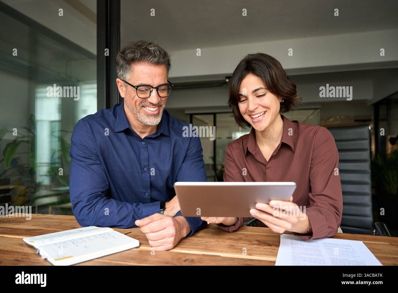 Two happy busy business executives team talking sitting in office using ...