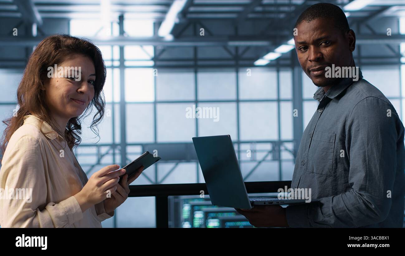 Portrait Of Happy System Administrators In Data Center Using Devices Verifying Firewall