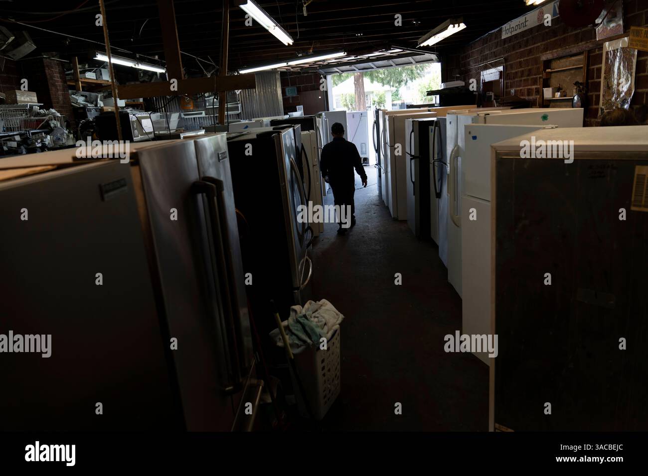 Tai Ly, from Vietnam, walks past used refrigerators at Appliance City ...