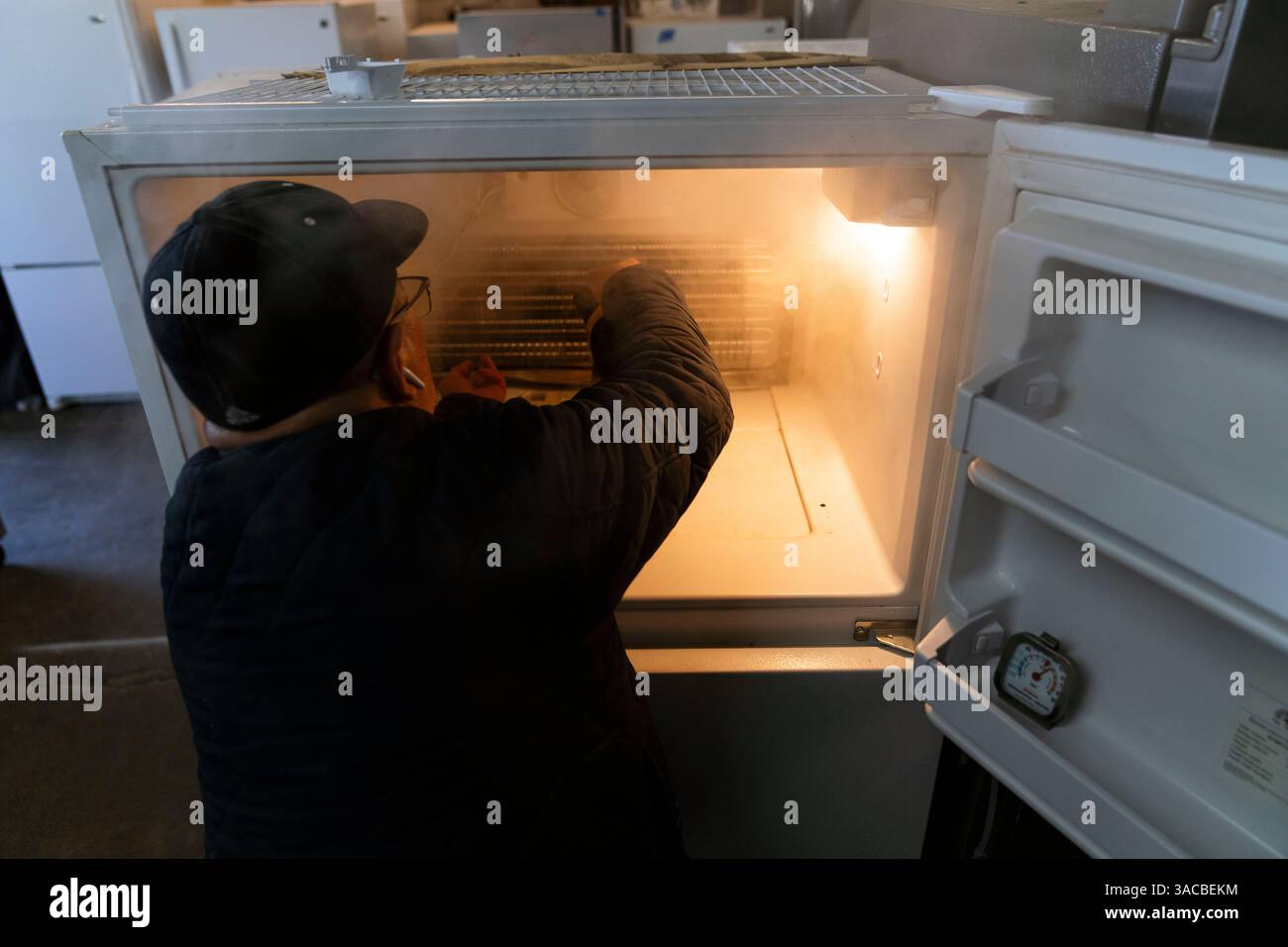 Tai Ly, from Vietnam, works on repairing a freezer at Appliance City on ...