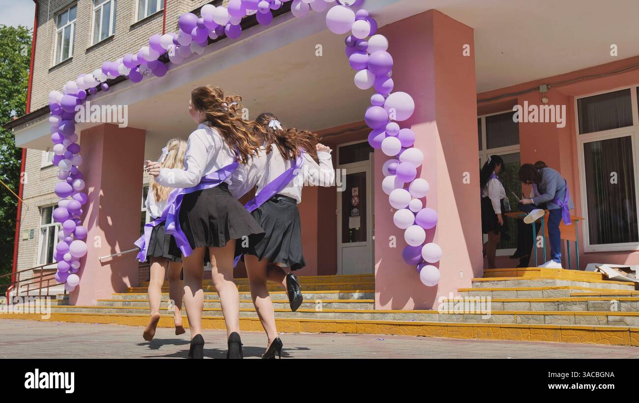 Happy students celebrating the end of the school year by running out of ...
