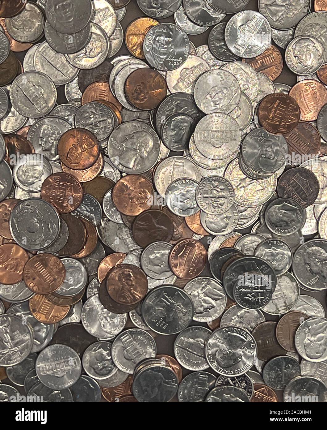 Various American coins of different denominations are spread out on a ...
