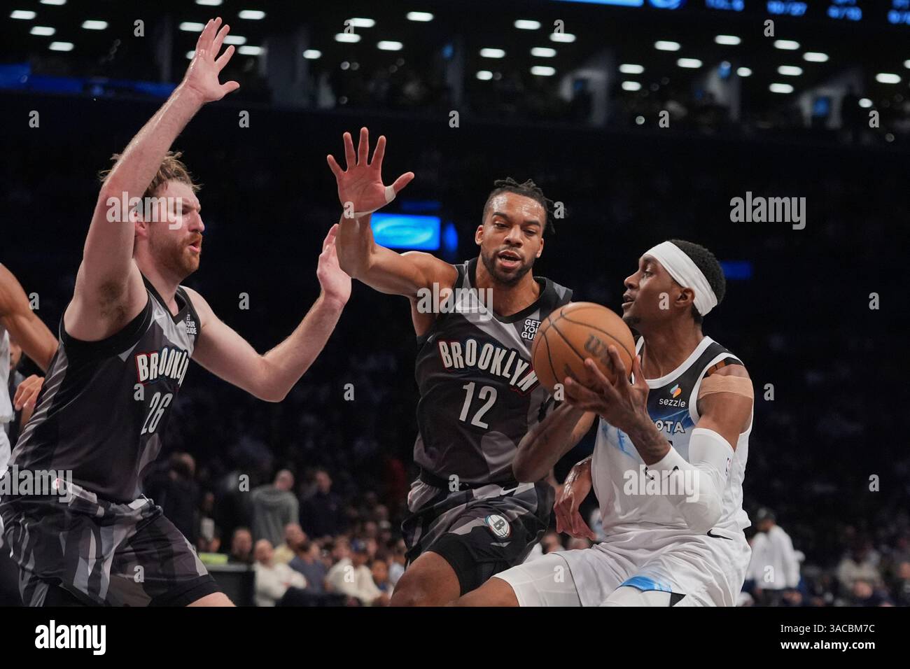 Brooklyn Nets' Drew Timme (26) and Tosan Evbuomwan (12) defend ...