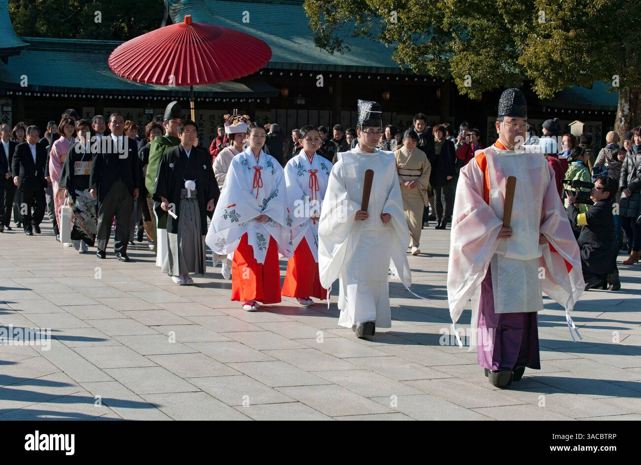 Formal wedding procession with bride, groom and family ushered by ...