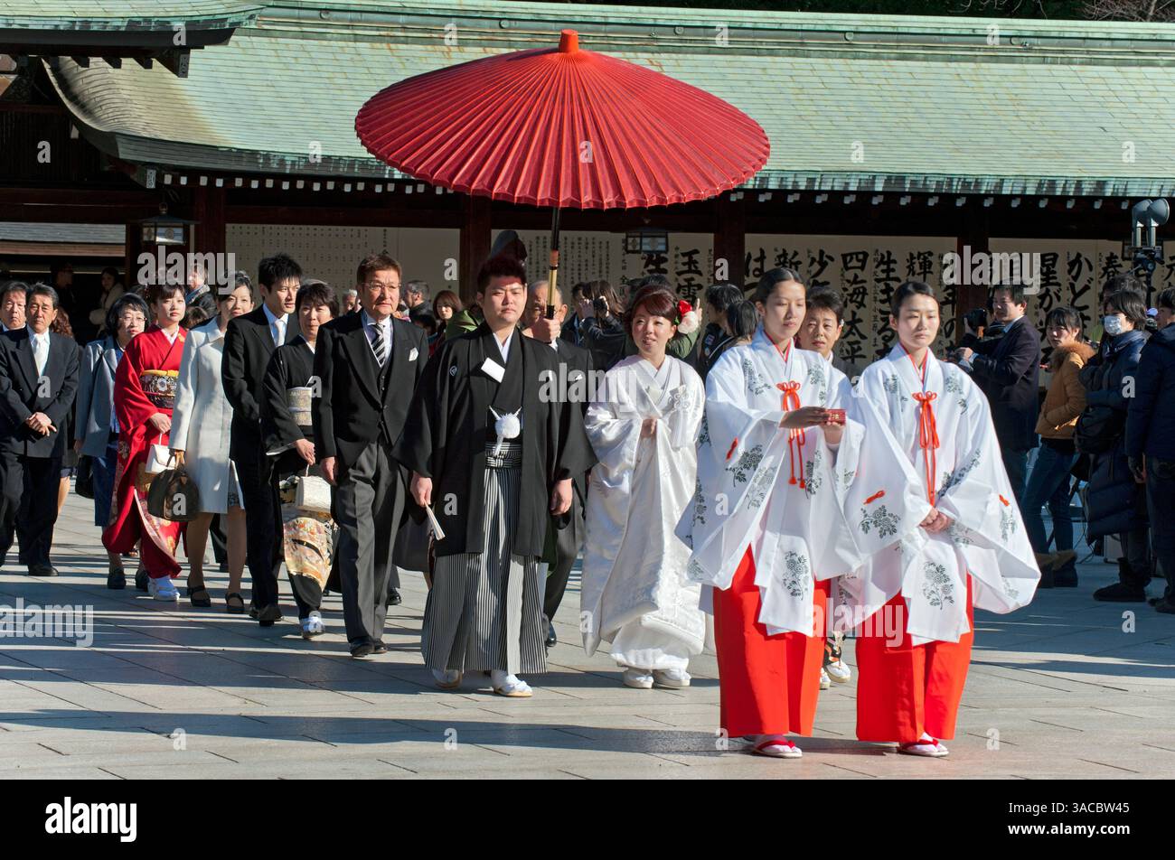 Formal wedding procession with bride, groom and family ushered by ...