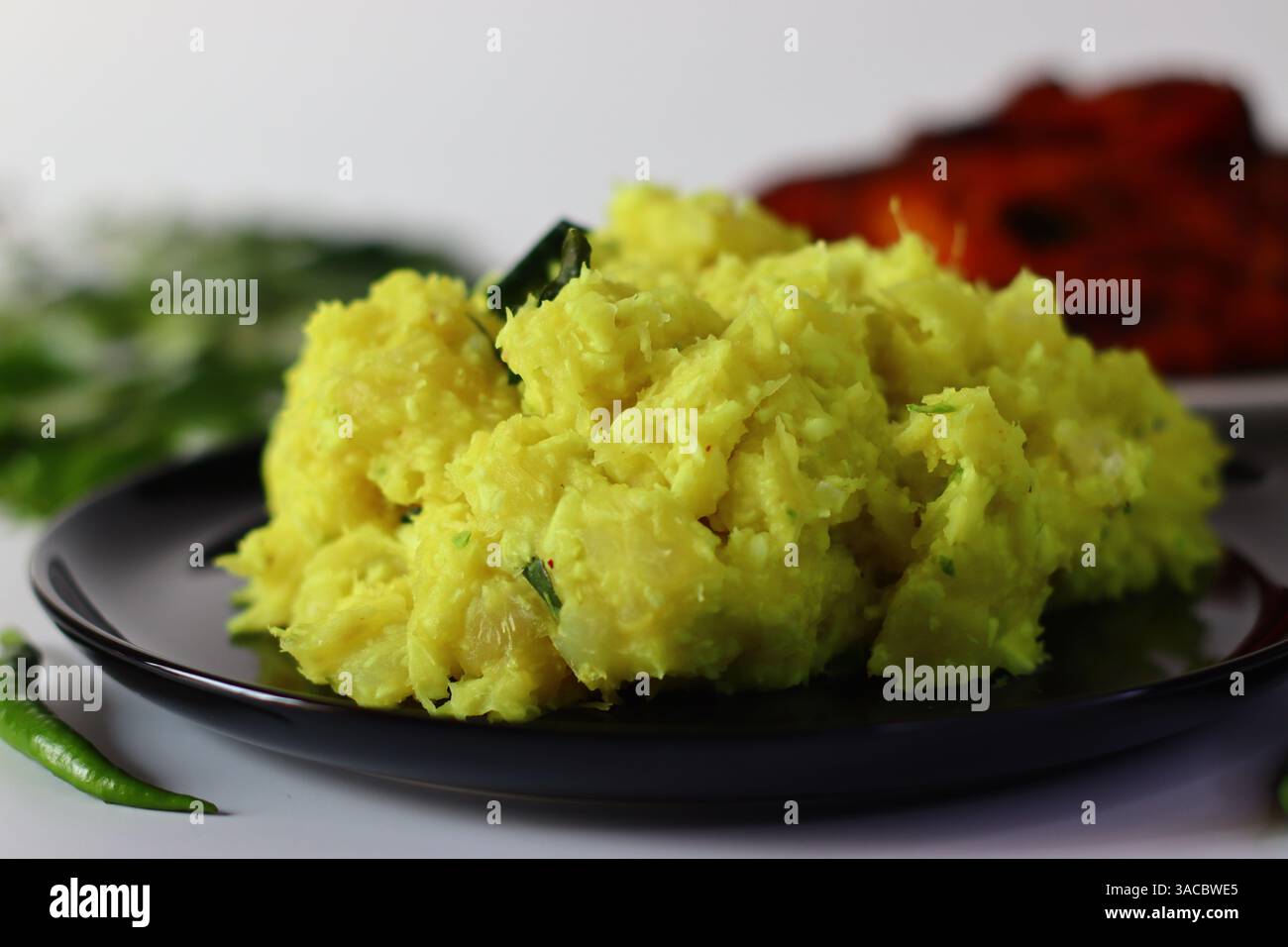 Boiled and mashed tapioca mixed with turmeric, green chilies, and curry ...