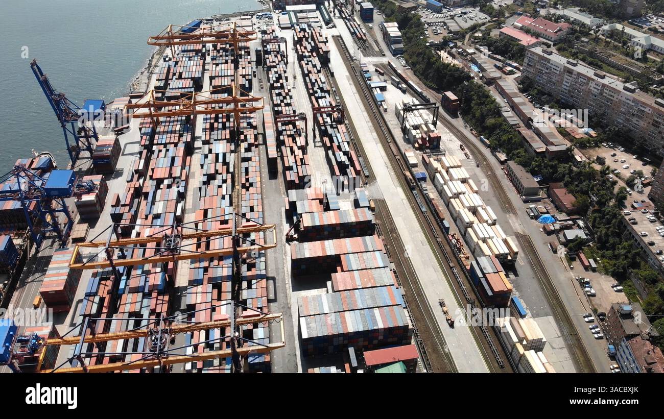 Aerial view of a bustling industrial port, featuring cargo cranes loading and unloading ...
