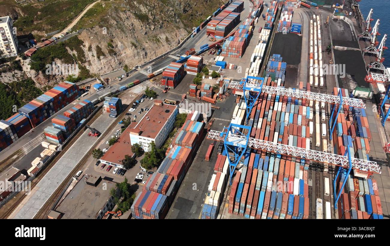 Industrial cargo port with cranes loading colorful shipping containers ...