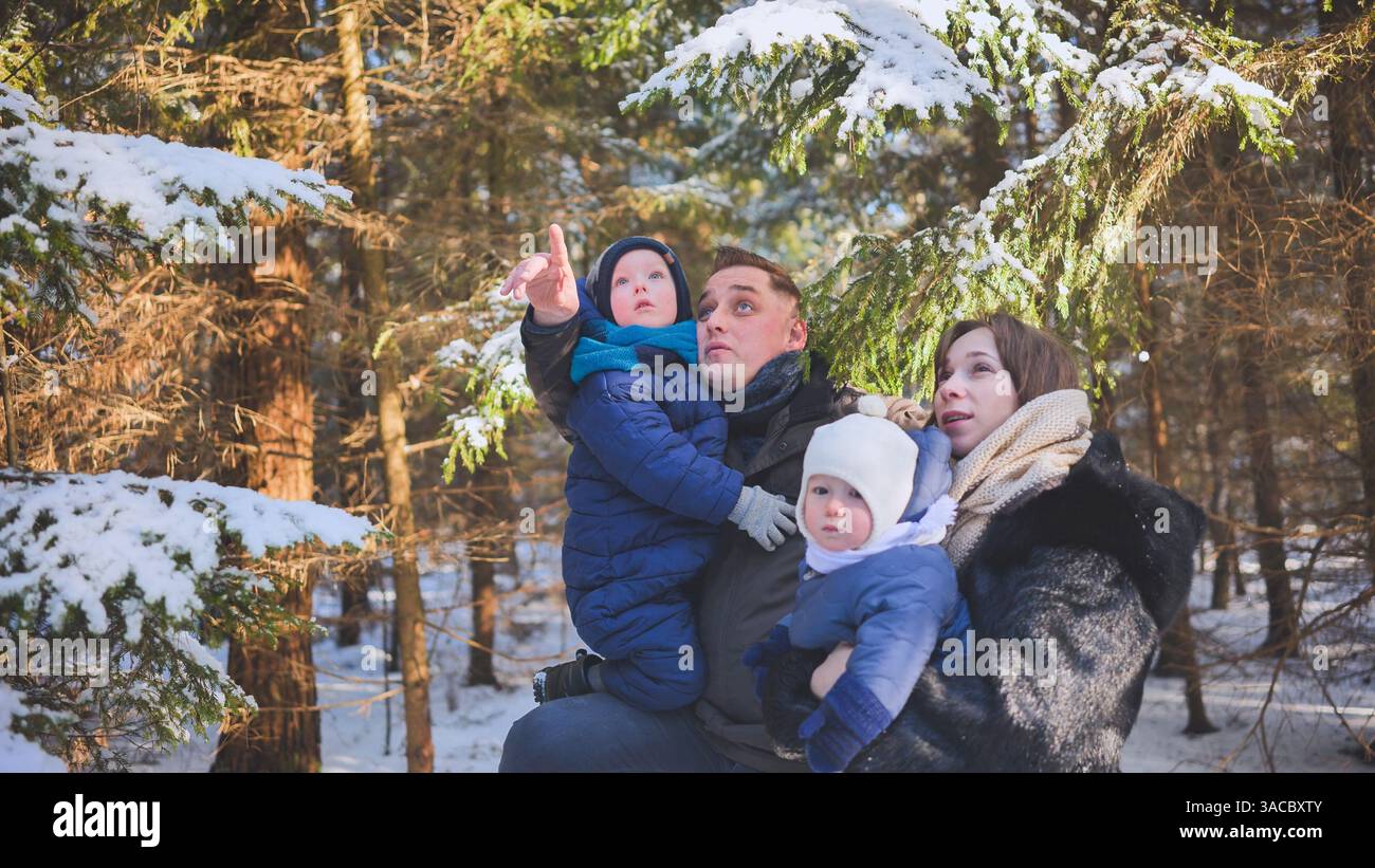 Family hiking through snow covered woodland, kids exploring winter ...