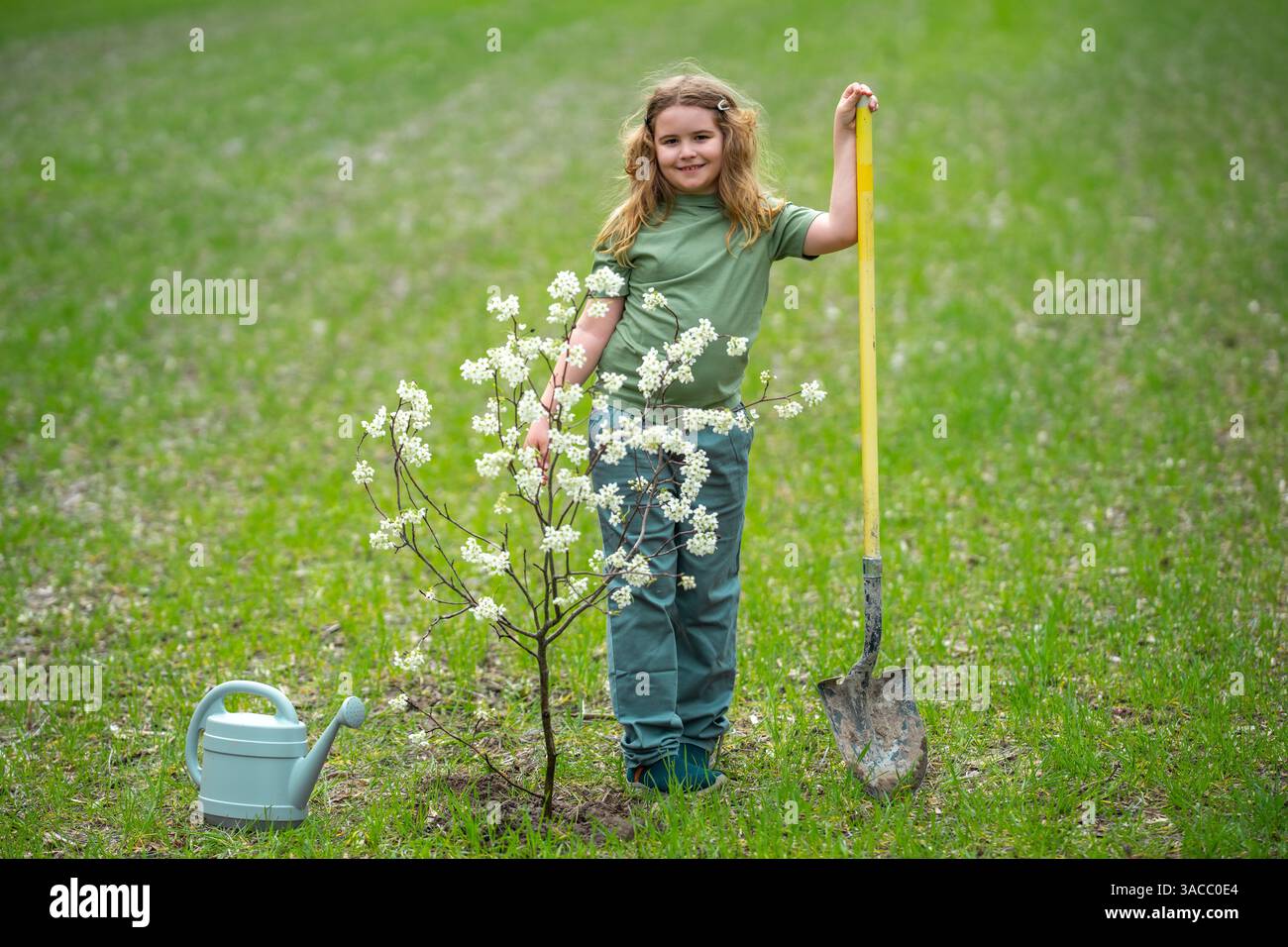 Child planting and watering tree in the garden. Spring activity of ...