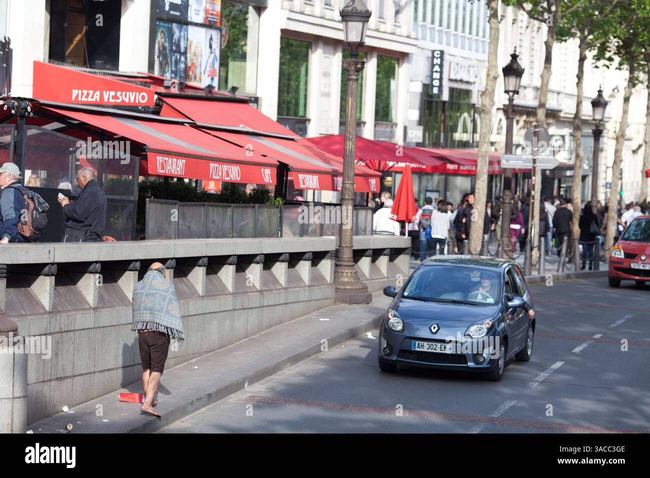 Poor man without shoes in Paris on the champs Elysees in summer 2013 ...