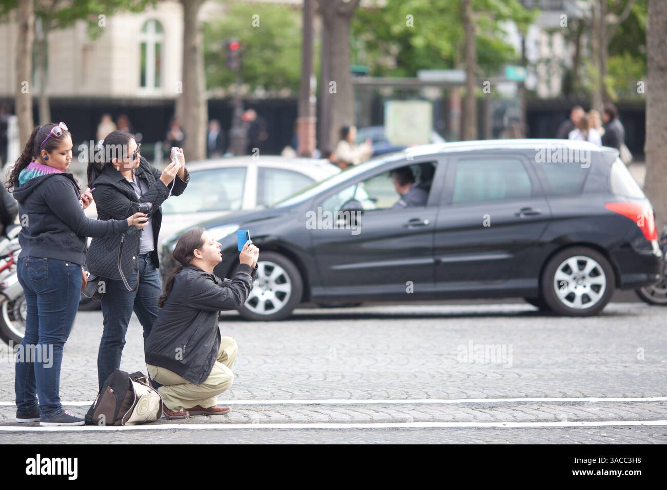 Tourist taking picture in the middle of the Traffic in Paris on the ...