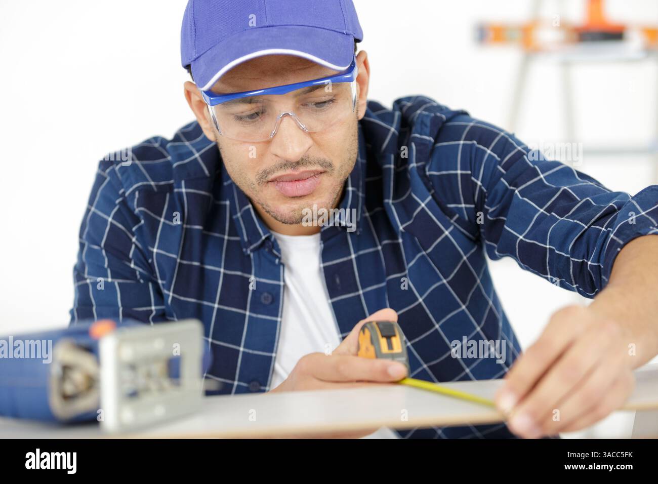 man measuring wood with tape measure Stock Photo - Alamy