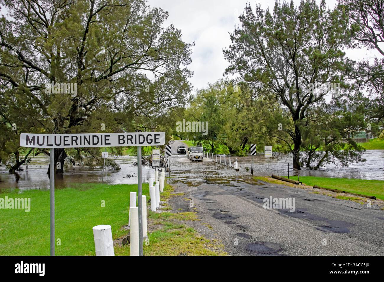 Cars crossing the flooded Muluerindie Bridge at Bandemeer NSW Australia ...