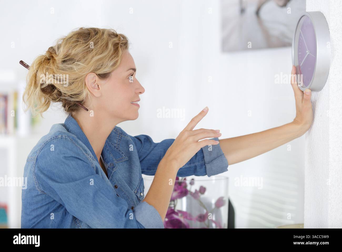 woman changing time on big wall clock Stock Photo - Alamy